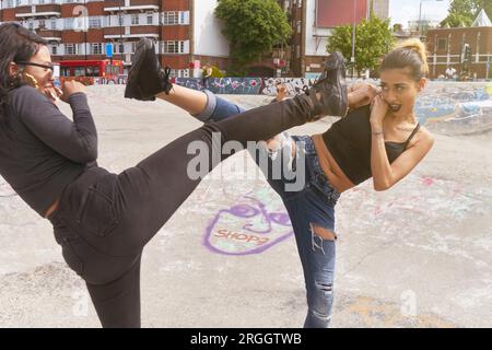 Young women play fighting at skate park Stock Photo - Alamy