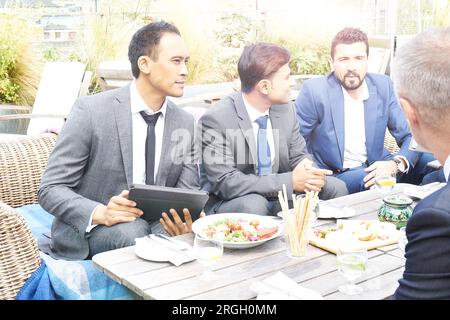 Businessmen at a dining table during a restaurant meeting Stock Photo ...