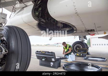 Worker fixing airplane wheel Stock Photo - Alamy