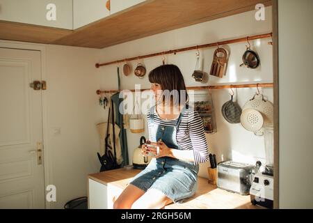 A person holds a cup of coffee while sitting at a cafe Stock Photo - Alamy