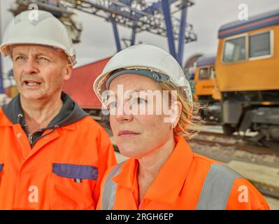 Dock workers talking by cargo train Stock Photo - Alamy