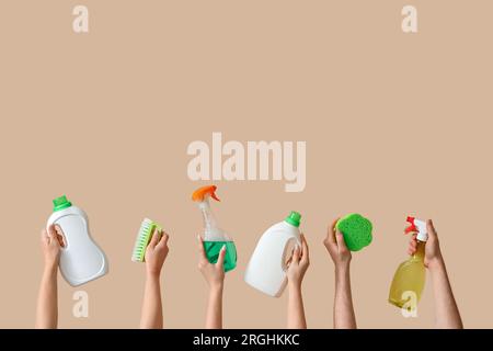 Women with cleaning supplies on beige background Stock Photo - Alamy