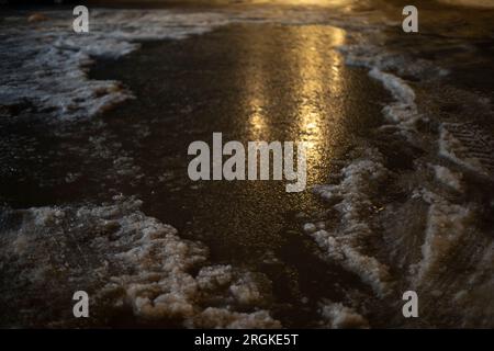 Big puddle at night. Lots of water in parking lot. Big puddle in city ...