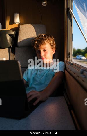 Preteen kid using laptop during online education near copy books and ...