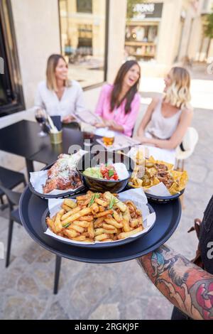 Female waiter carrying food on tray closeup. Customer service in ...