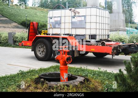 fire hydrant on the background of a trailer in water tanks for watering ...