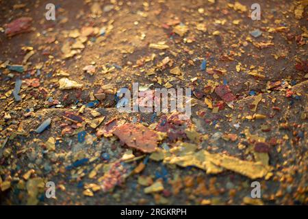 Pieces of paint lie on asphalt. Texture of colored dirt. Small dust ...