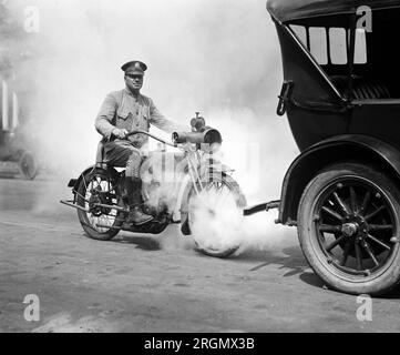 Police on motorcycle trailing car with smoke ca. 1923 Stock Photo - Alamy