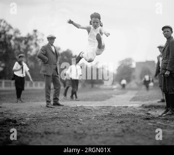 Grade school track and field athelete participating in a long jump ...