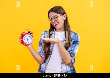 Teen girl organizing her schedule with a clock. Teen girl hold alarm ...