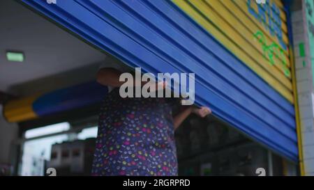 Person opening local storefront garage. Woman sliding up business ...