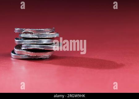 broken bent and rusting metal coins on a red background Stock Photo - Alamy