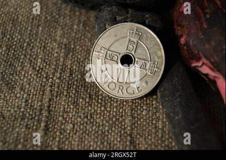 1 Krone Harald V. Norwegian coin and stones on natural linen fabric ...