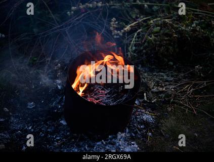 Burning garbage in the tank. Incineration of garbage in an iron bucket ...