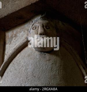 Face carved on capital of pillar supporting early Norman chancel arch ...
