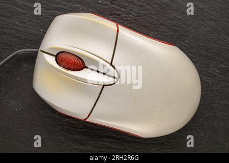 One computer mouse on slate stone, after 20 years of use, top view ...