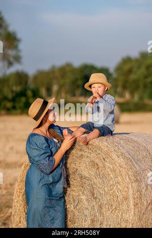 Happy mom with a child in a field with poppies Stock Photo - Alamy