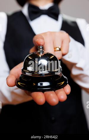 Asian hotel concierge holding restaurant sign to indicate direction ...