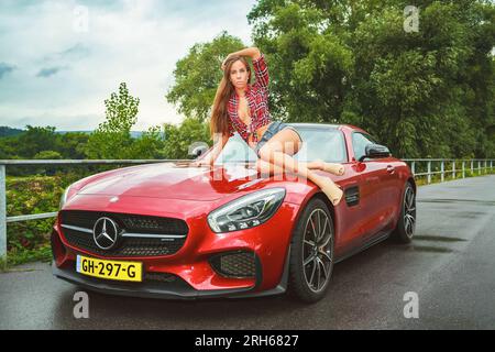 Red Mercedes AMG-GTS sportscar (2015) parked on a road with stylish ...