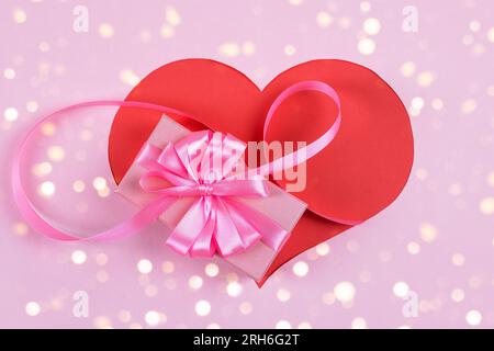Heart made of pink satin ribbon on table against blurred lights Stock ...