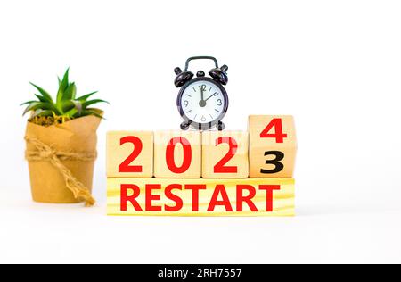 2024 restart new year symbol. Businessman turns a wooden cube and ...