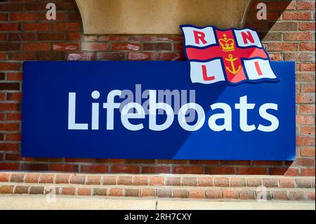 RNLI Lifeboats sign on the wall of the Lifeboat Station on the seafront ...