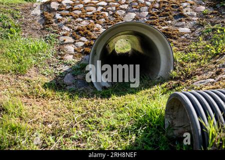 Trough the pipe. Stormwater and road infrastructure ditch Stock Photo ...