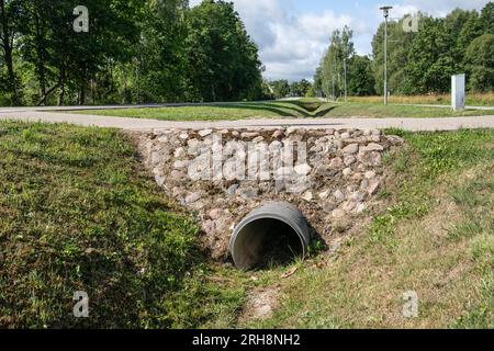 Trough the pipe. Stormwater and road infrastructure ditch Stock Photo ...