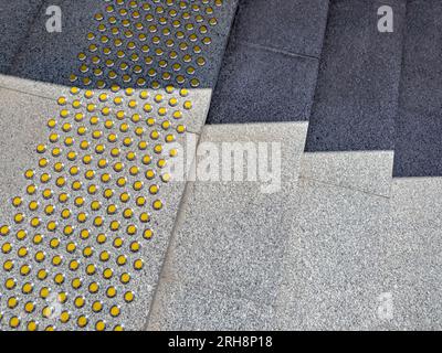 granite staircase with yellow nonskid bumpy markings for visually ...