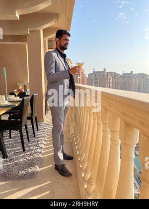 Young Men enjoying view of Peral Qatar Porto Arabia from Balcony Stock ...