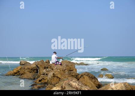 An Israeli man fishing at the beautiful beach in Bat Yam, Israel Stock ...