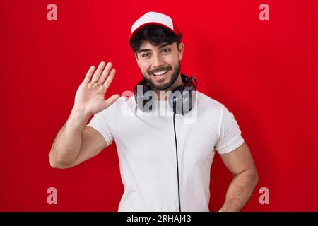 Hispanic man with beard wearing gamer hat and headphones making fish ...