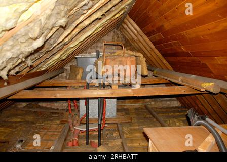 Interior of domestic loft with insulation and cold water tank and ...