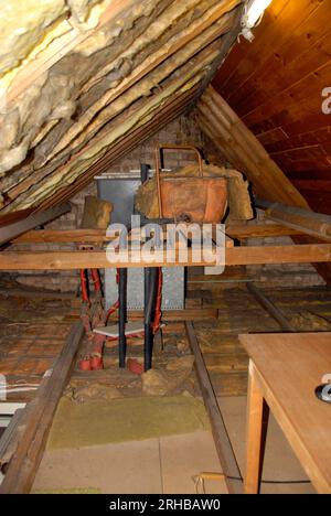 Interior of domestic loft with insulation and cold water tank and ...