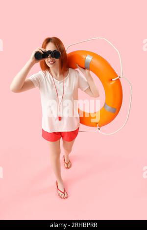Female lifeguard with binoculars and ring buoy on beige background ...