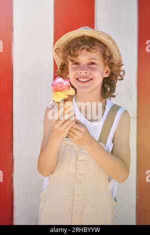 Adorable boy with ice cream against blue background Stock Photo - Alamy