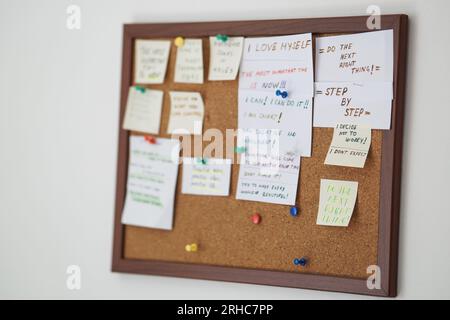 Cork board with stick notes with motivational sentences on them on a ...