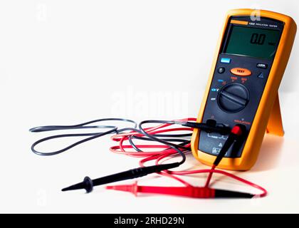 Digital multimeter with probes and green backlit display isolated on a ...