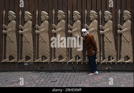 A Parsi man poses for a photo near the carvings of guardians of faith ...