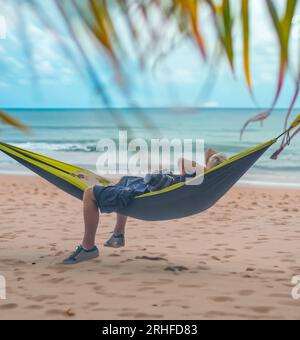 A Man Enjoying A Nap In A Hammock On A Beach In Hawaii Stock Photo - Alamy