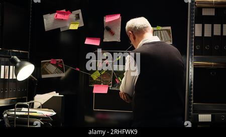 Law agent examine surveillance photos on laptop to connect the dots and ...