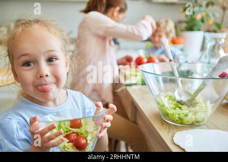 Playful blond girl sticking out tongue against white background Stock ...