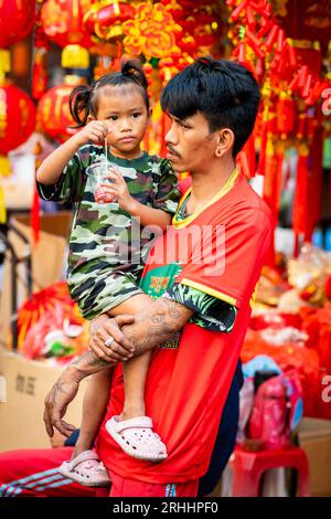 A proud young Thai dad plays with his beautiful little daughter in ...
