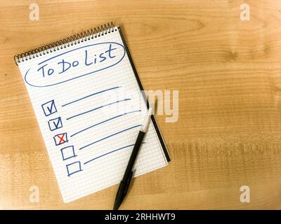 to do list checklist hand written on notepad paper lay on wooden table ...