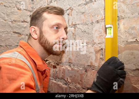 engineer checking wall with spirit level Stock Photo - Alamy