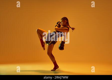 Leg kick. MMA fighter, teen girl training, fighting against purple ...