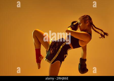 Leg kick. MMA fighter, teen girl training, fighting against purple ...
