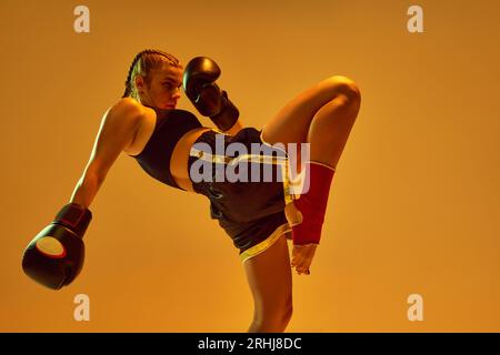 Leg kick. MMA fighter, teen girl training, fighting against purple ...