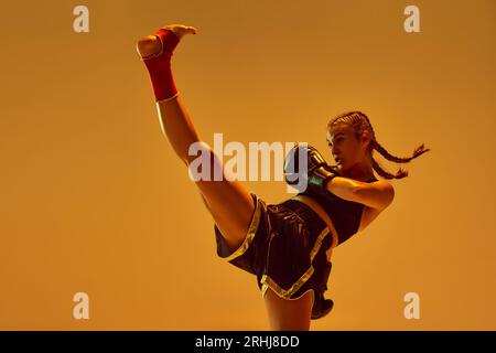 Leg kick. MMA fighter, teen girl training, fighting against purple ...