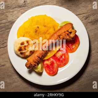 chicharron with patacones, arepa and sliced tomatoes - traditional ...